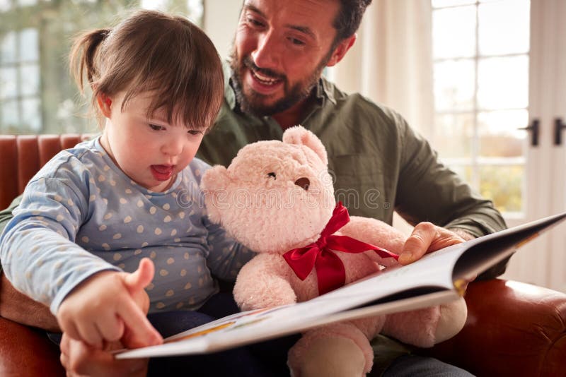 Father with Down Syndrome Daughter Reading Book at Home Together Stock ...