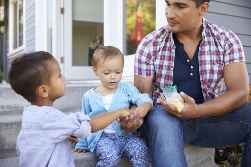 Father Giving Children Candy on Steps Outside Hose Stock Photo - Image ...