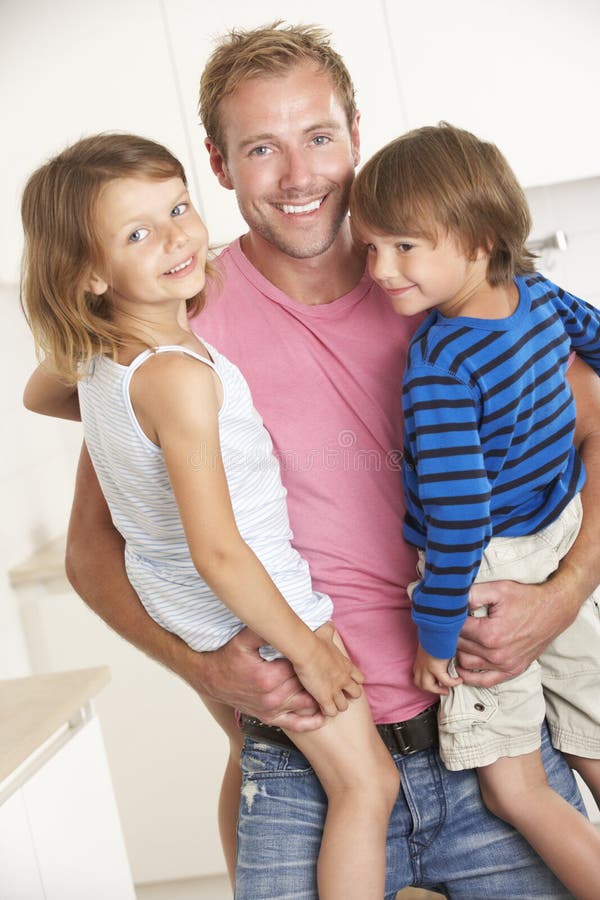 Father Giving Children Cuddle at Home Stock Photo - Image of thirties ...