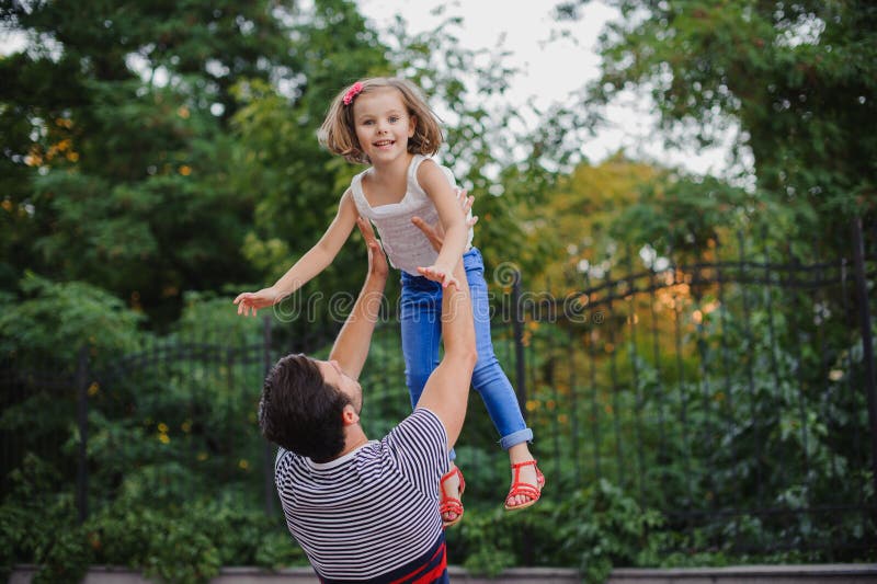 Father Having Fun and Throwing Up His Daughter in Park Stock Photo ...