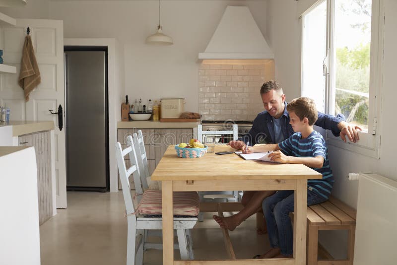 Father Helping Son with Homework Sitting at Kitchen Table Stock Image ...
