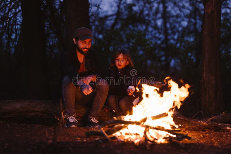 The Father and His Little Son Sitting on the Logs in the Forest in ...