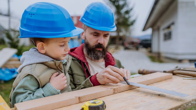Father and His Little Son Working in Front of Their Unfinished House ...