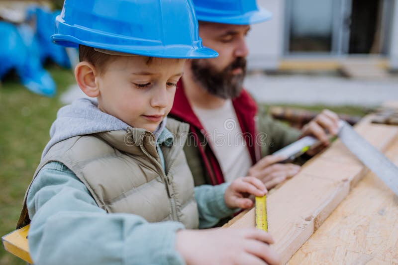 Father and His Little Son Working in Front of Their Unfinished House ...