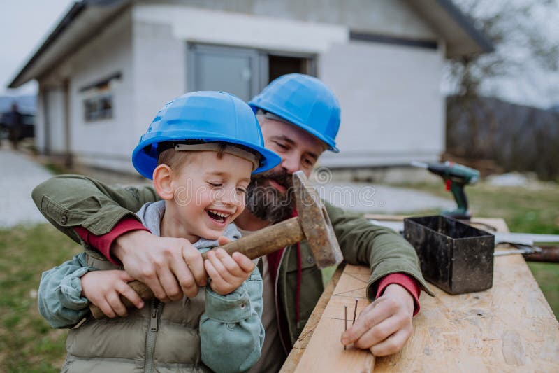 Father and His Little Son Working in Front of Their Unfinished House ...