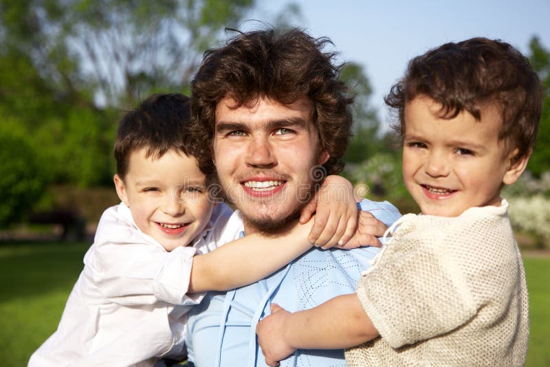 Father holding two sons stock image. Image of happiness - 14431363