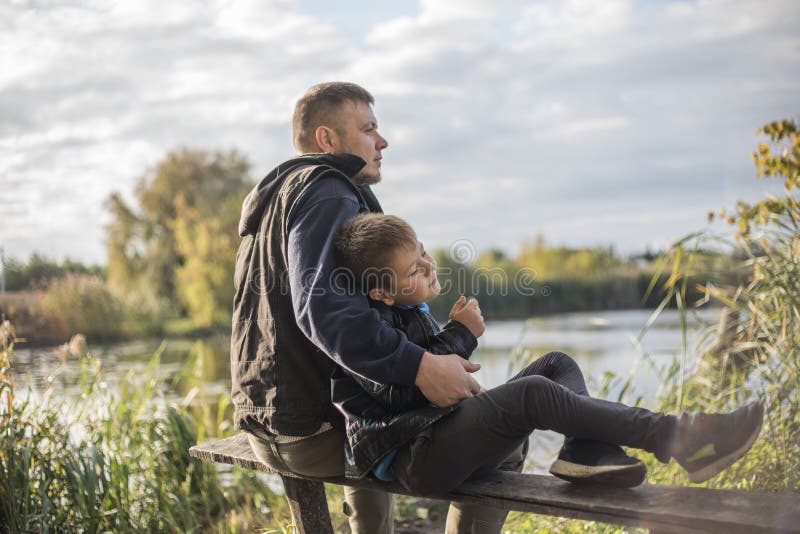 Father Hugging His Son Outdoors on the Bench. Precious Moments between ...