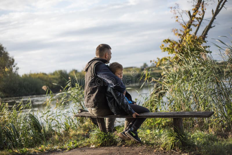 Father Hugging His Son Outdoors on the Bench. Precious Moments between ...