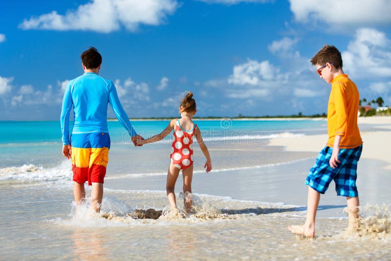 Father with kids at beach stock photo. Image of back - 69652598