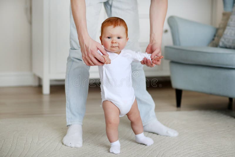 Father and Little Dauther. Baby Taking First Steps with Father Help in ...