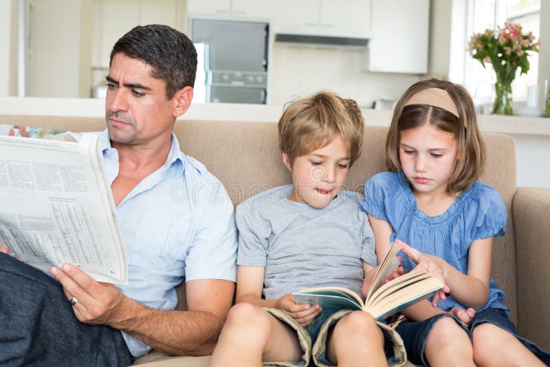 Father with Newspaper while Children Reading Book Stock Photo - Image ...