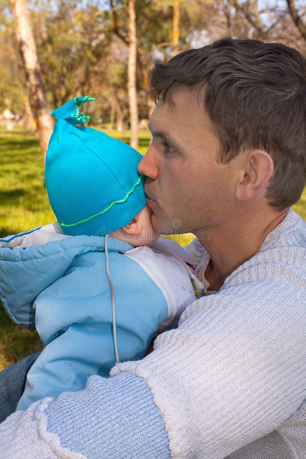 The Father in Park on a Grass Sad Kisses the Son Stock Photo - Image of ...