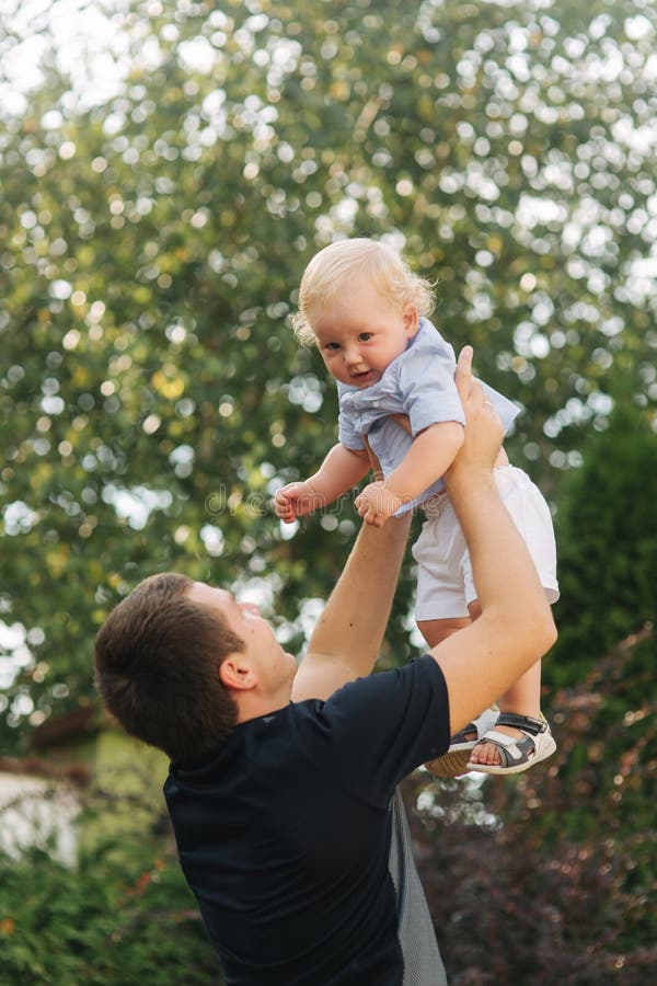 Father Play with Son Outside. Background of Green Tree Stock Photo ...