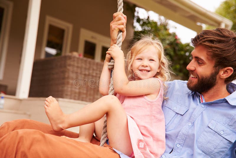 Father Playing with Daughter on a Rope Swing in a Garden Stock Image ...