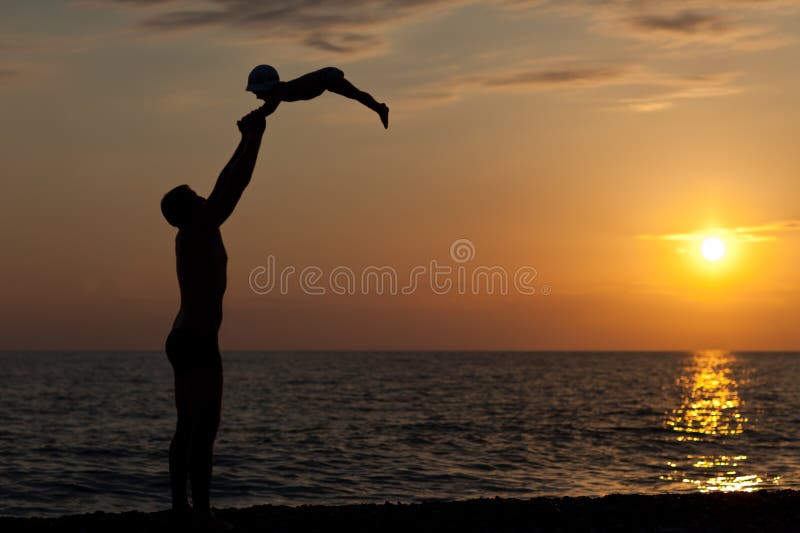 Father Plays with Son Against a Sunset Stock Photo - Image of young ...