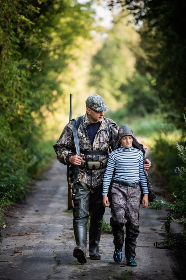 Father With Gun Showing Something To Son While Hunting On A Nature ...
