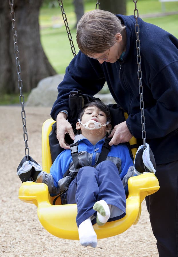 Father Pushing Disabled Son on Handicap Swing Stock Image - Image of ...