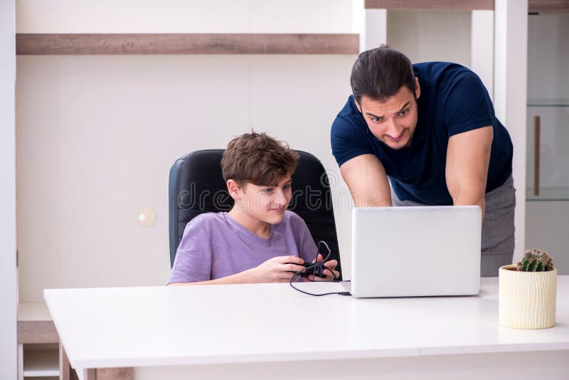 Young Father and Schoolboy Playing Computer Games at Home Stock Photo ...