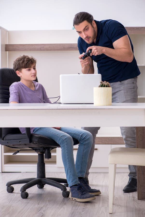 Young Father and Schoolboy Playing Computer Games at Home Stock Photo ...