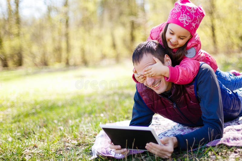 Father Showing Game in Tablet Pc To His Daughter in the Park Stock ...