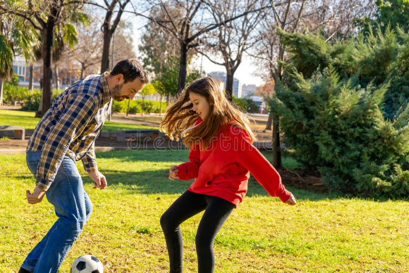Father with a Small Daughter Playing with a Ball in Spring Nature Stock ...