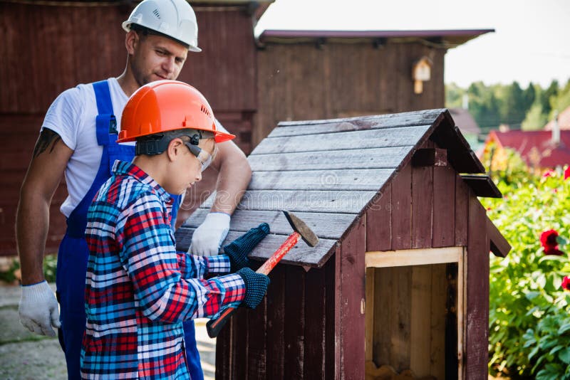 Father and Son Building Tree House Together Using Hammer Stock Photo ...