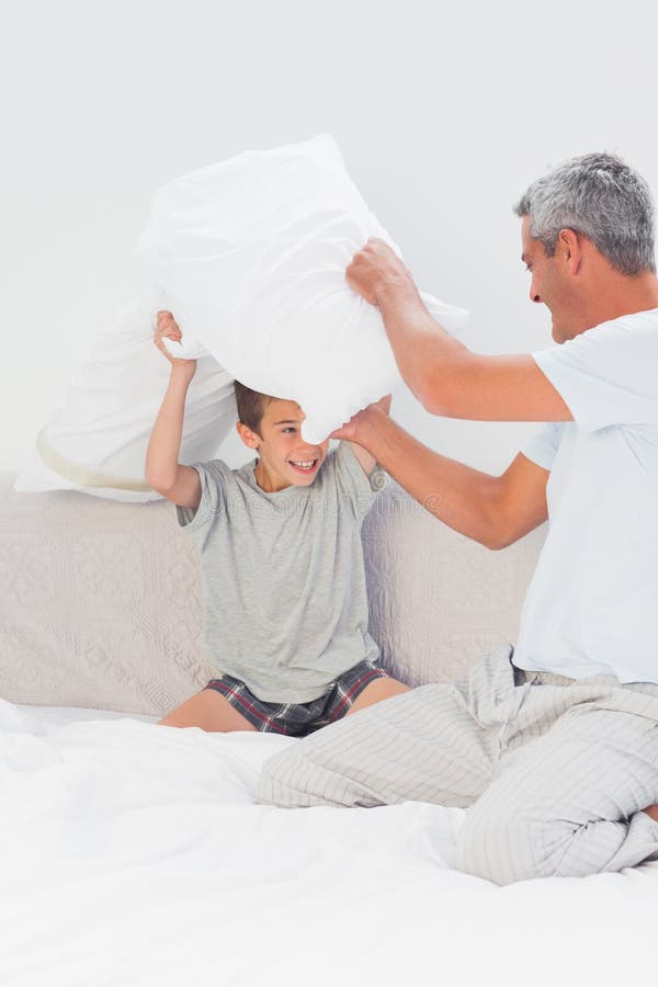 Father and Son Fighting Together with Pillows on Bed Stock Image ...