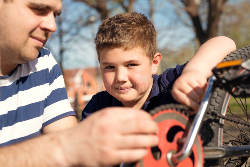 Father and son fixing bike stock image. Image of maintenance - 69399575