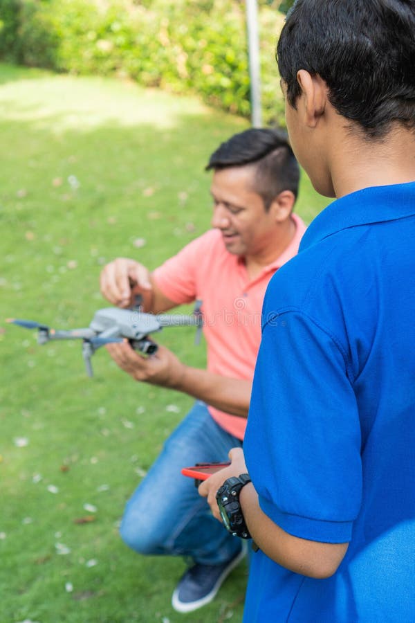 Father and Son Flying a Drone in a Park Stock Photo - Image of vehicle ...