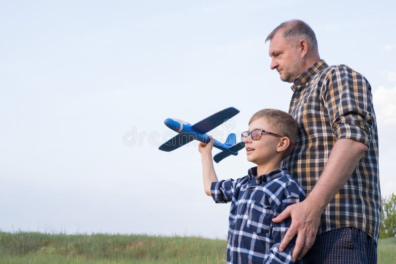 Father and Son Having Fun in the Field Playing with an Airplane Stock ...
