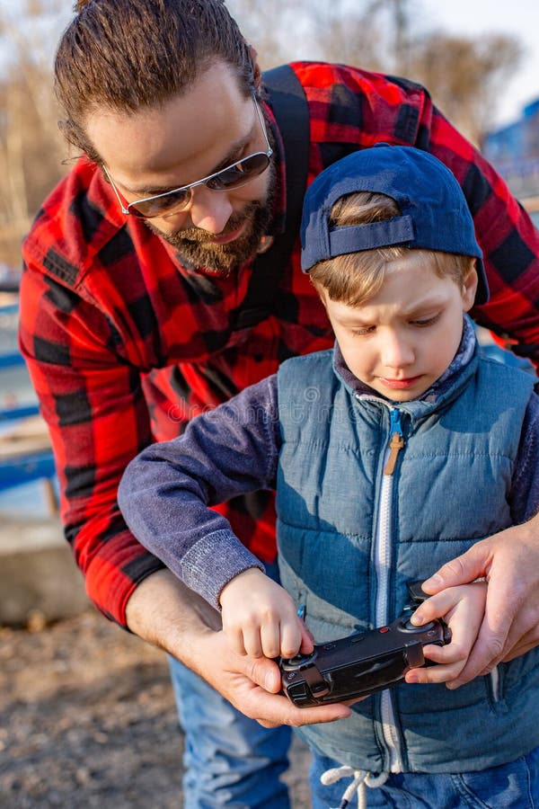 Father and Son Holding Remote Control Joystick and Piloting ...