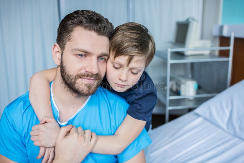 Father and Son Hugging while Sitting on Hospital Bed Stock Photo ...