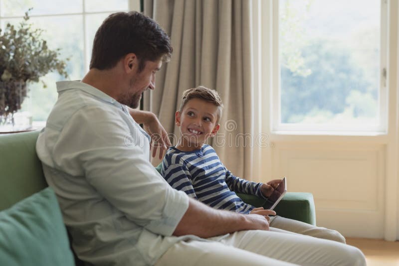 Father and Son Interacting with Each Other on Sofa in a Comfortable ...