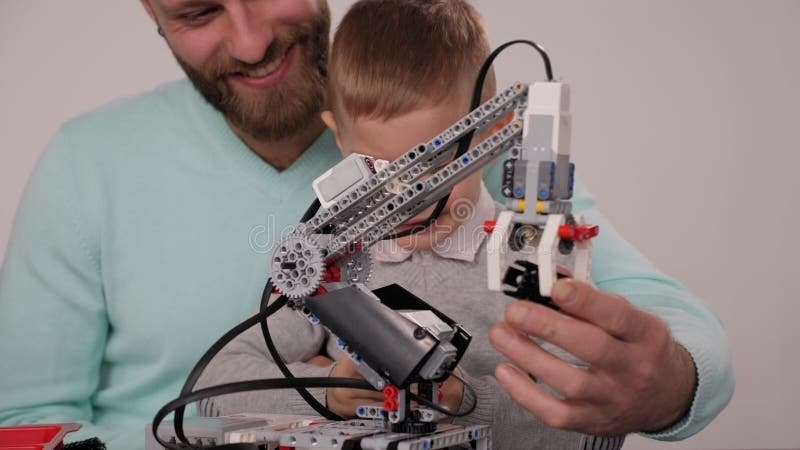 Father and Son Play with Programmed Robots in the School of Robotics ...