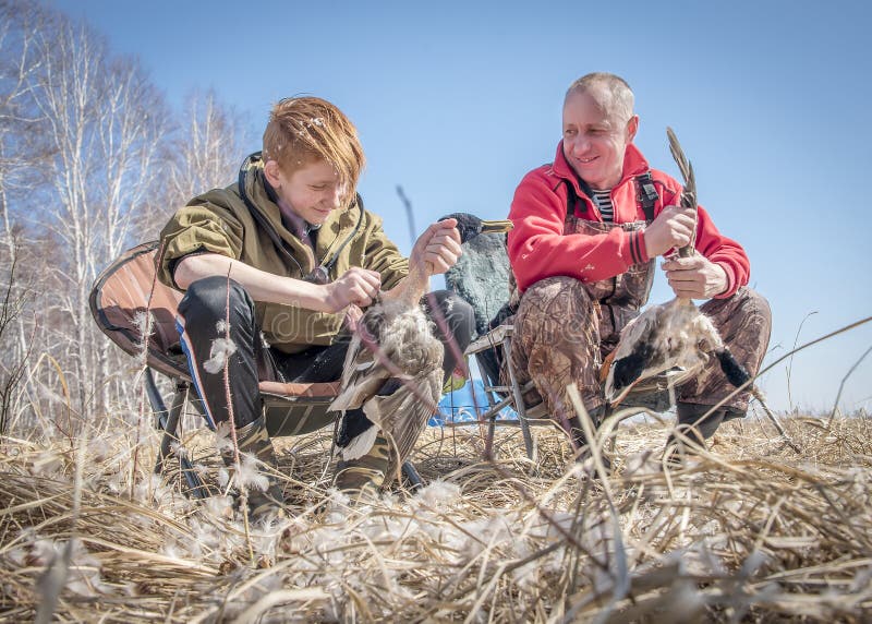 Father and Son Plucking Ducks after Hunting in a Forest Clearing Stock ...