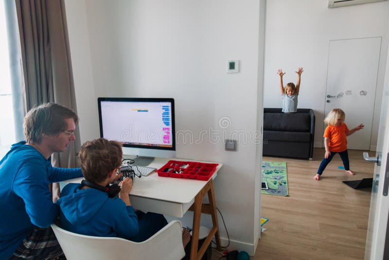 Father and Son Programming Robot while Kids Dance and Play at Home ...
