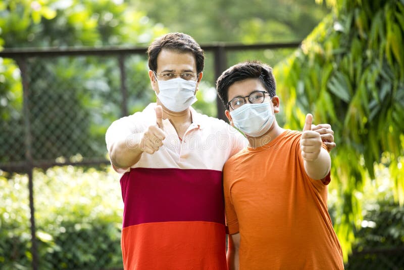 Father and Son with Protective Face Mask Looking at Camera Stock Photo ...