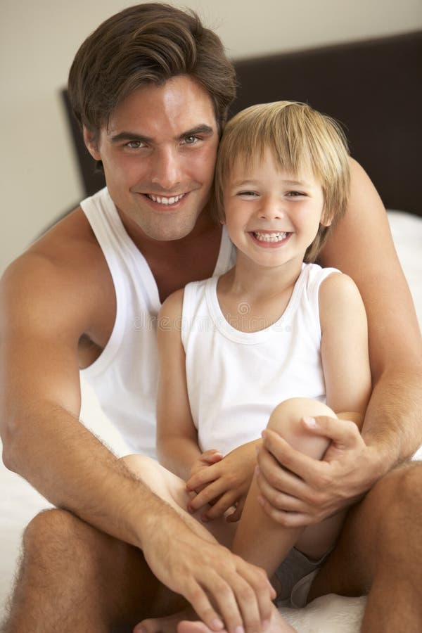 Father and Son Relaxing on Bed Stock Photo - Image of indoors, laying ...
