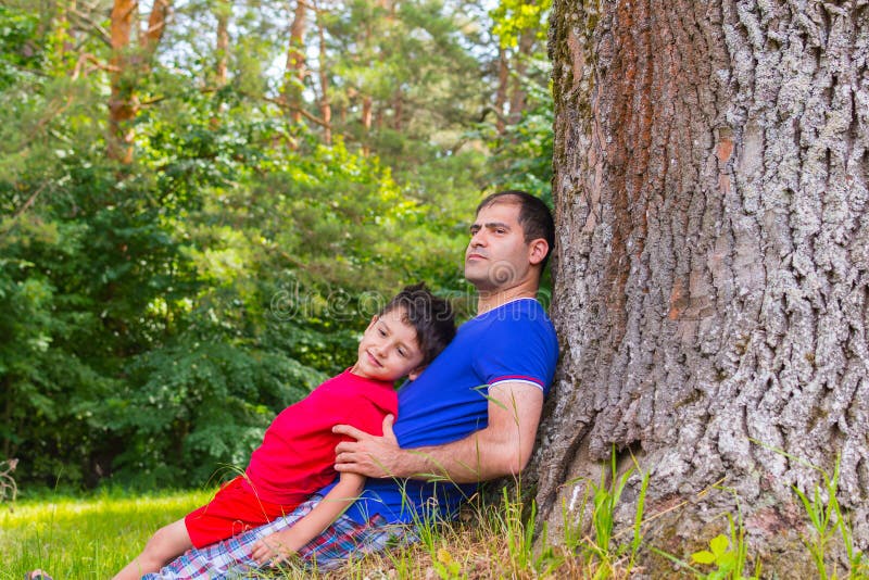 Father and Son Resting Under a Tree in the Summer Stock Image - Image ...