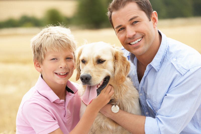 Father and Son Sitting with Dog on Straw Bales in Stock Image - Image ...