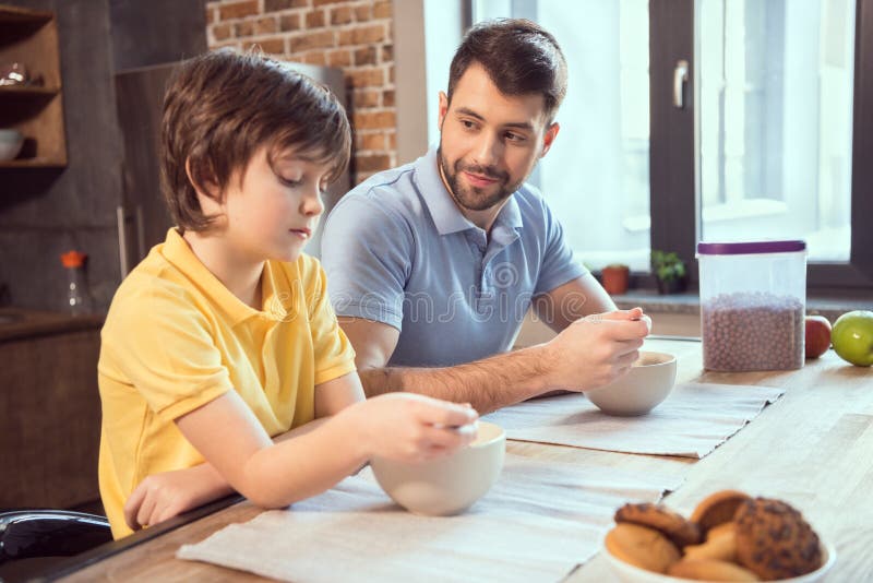 Father and Son Sitting at Kitchen Table and Having Chocolate Balls ...