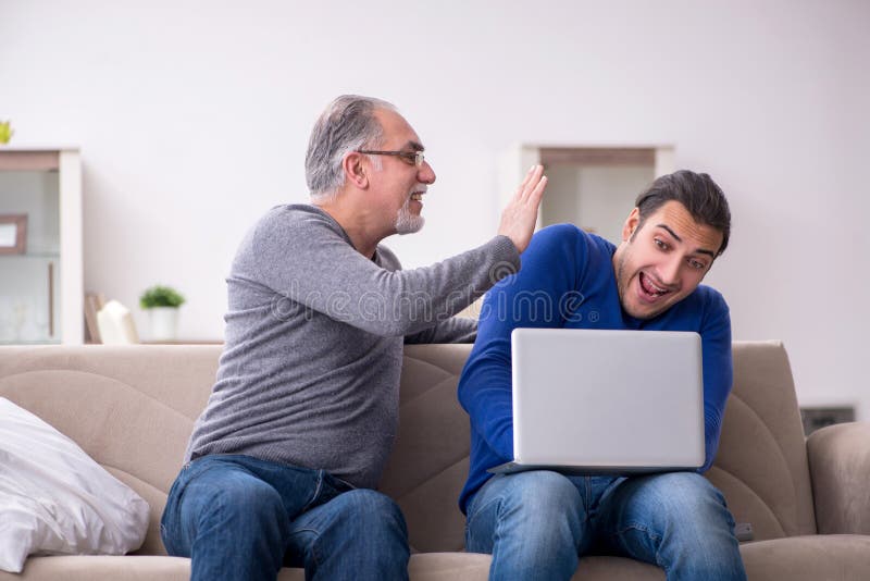 Father and Son Sitting on the Sofa with Computer Stock Image - Image of ...