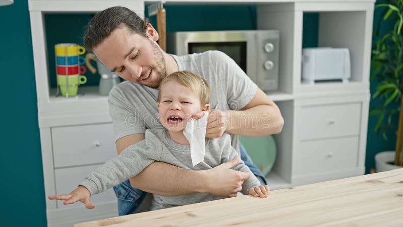 Father and Son Sitting on Table Cleaning Face Crying at Dinning Room ...