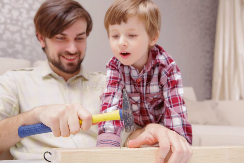 Father and son use hammer stock image. Image of game - 53329367