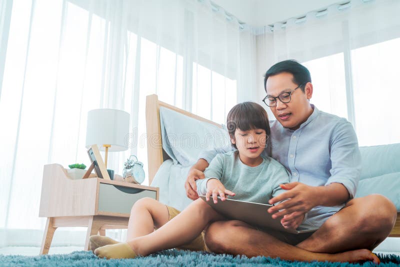 Father and Son is Using Computer Laptop for Education Together at Home ...