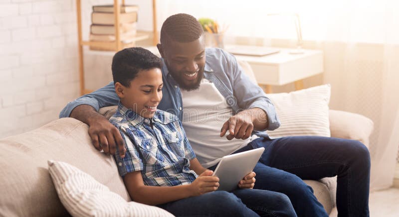 Father and Son Using Digital Tablet at Home, Checking New Application ...