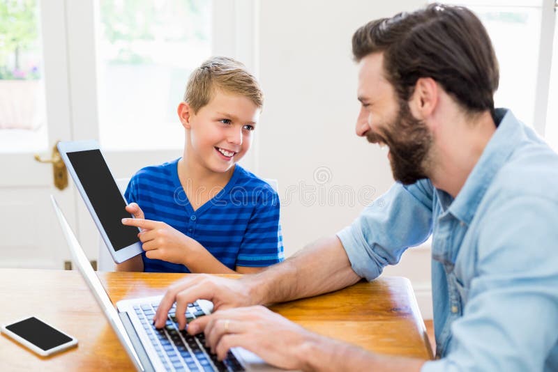 Father and Son Using Laptop and Digital Tablet Stock Photo - Image of ...