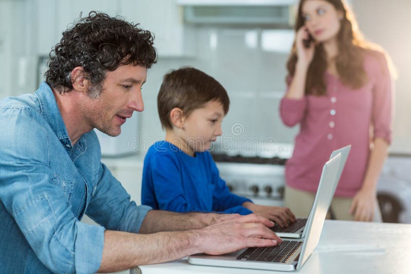 Father Calling with Mobile Phone with His Family Eating Breakfast Stock ...