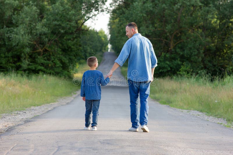Father and Son Walk Along the Road Holding Hands Stock Photo - Image of ...