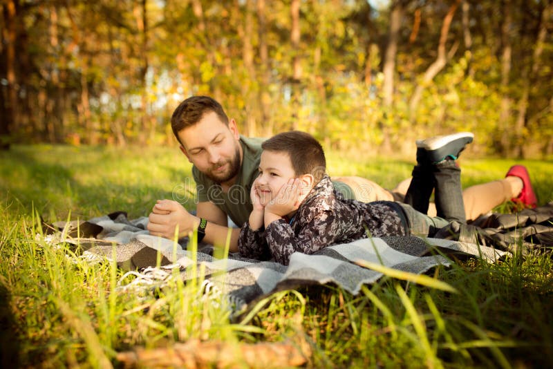 Father And Son Walking And Having Fun In Autumn Forest Look Happy And